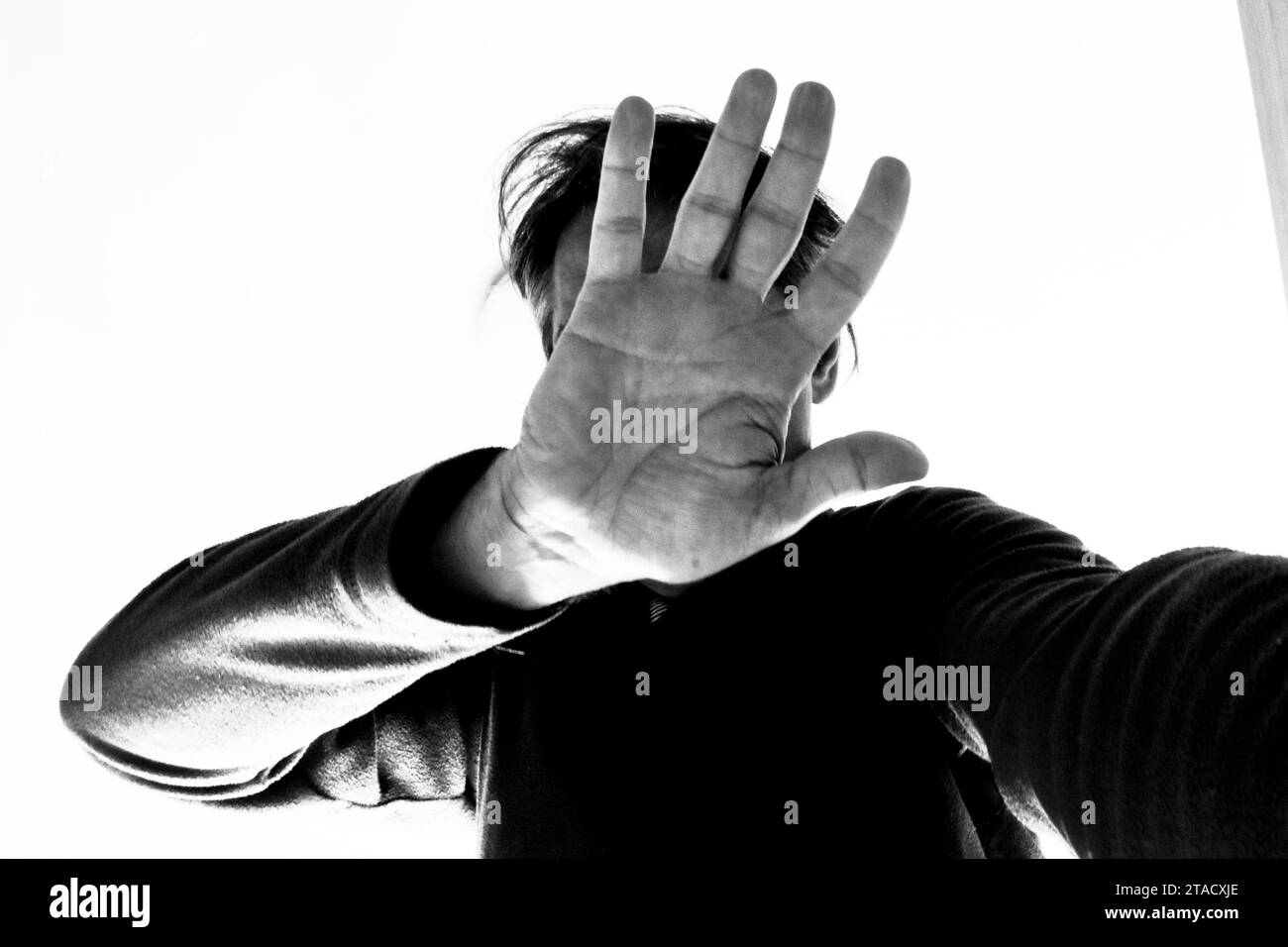 Man showing his hand, hiding his face Stock Photo - Alamy
