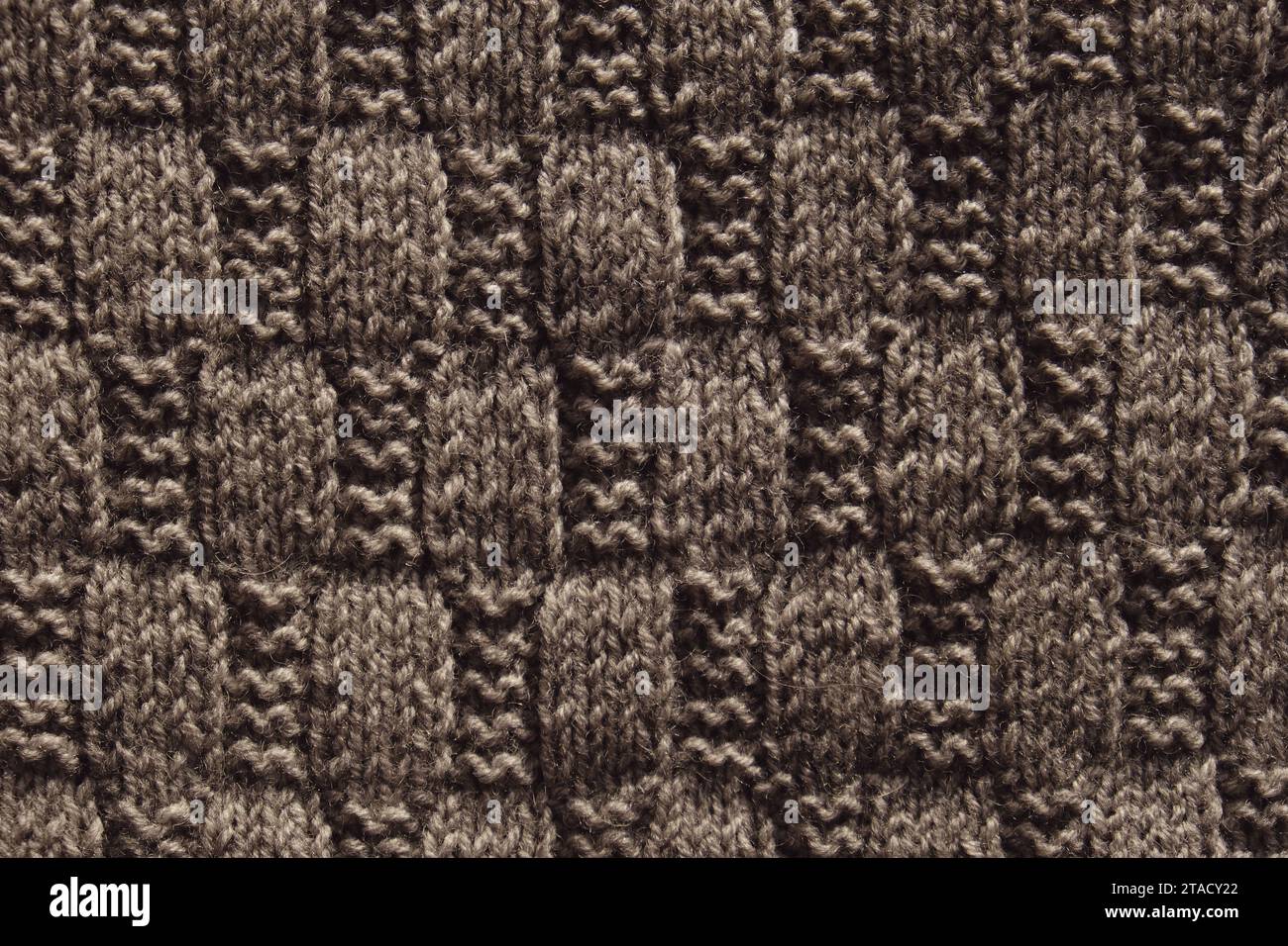 Background with gray knitted leaf shape, knitting pattern with cables ...