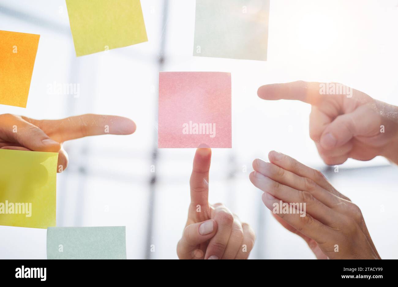 Hand pointing at pink paper or post against office background Stock ...