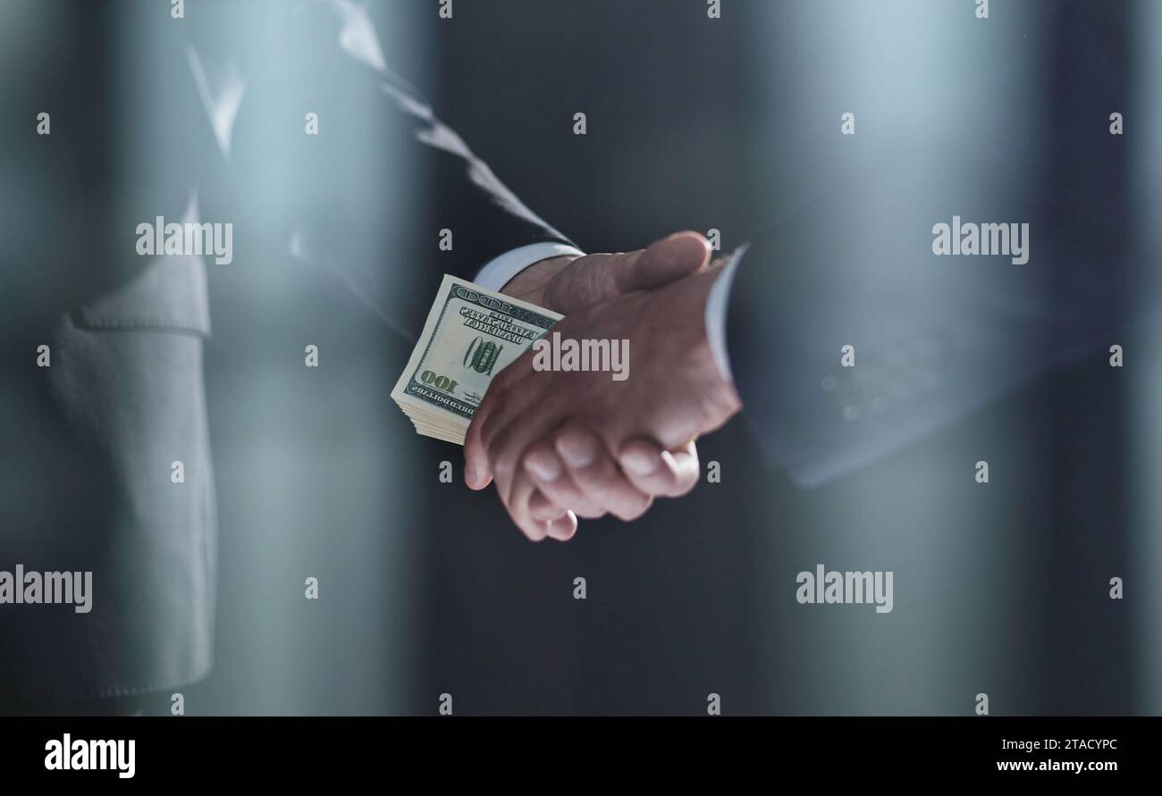Handshake with the transfer of money on a black background Stock Photo ...