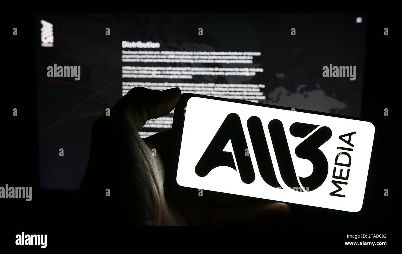 Person holding mobile phone with logo of British television production ...