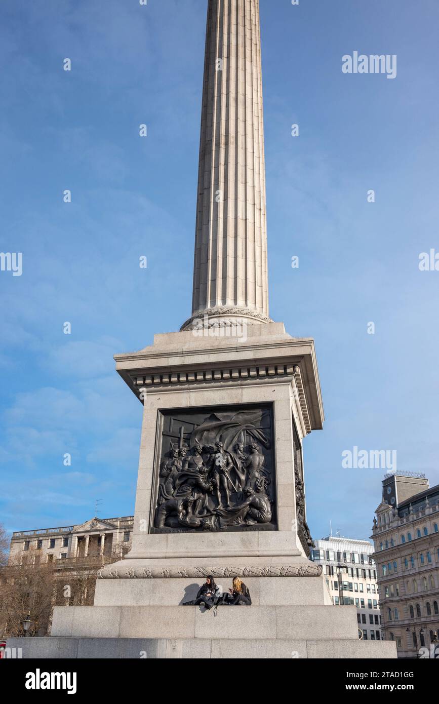 Two young women sitting on the steps at the base of Nelson's Column ...