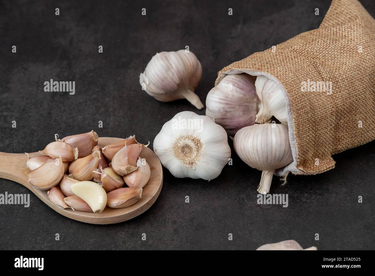Big and small heads of garlic on a black background Stock Photo - Alamy