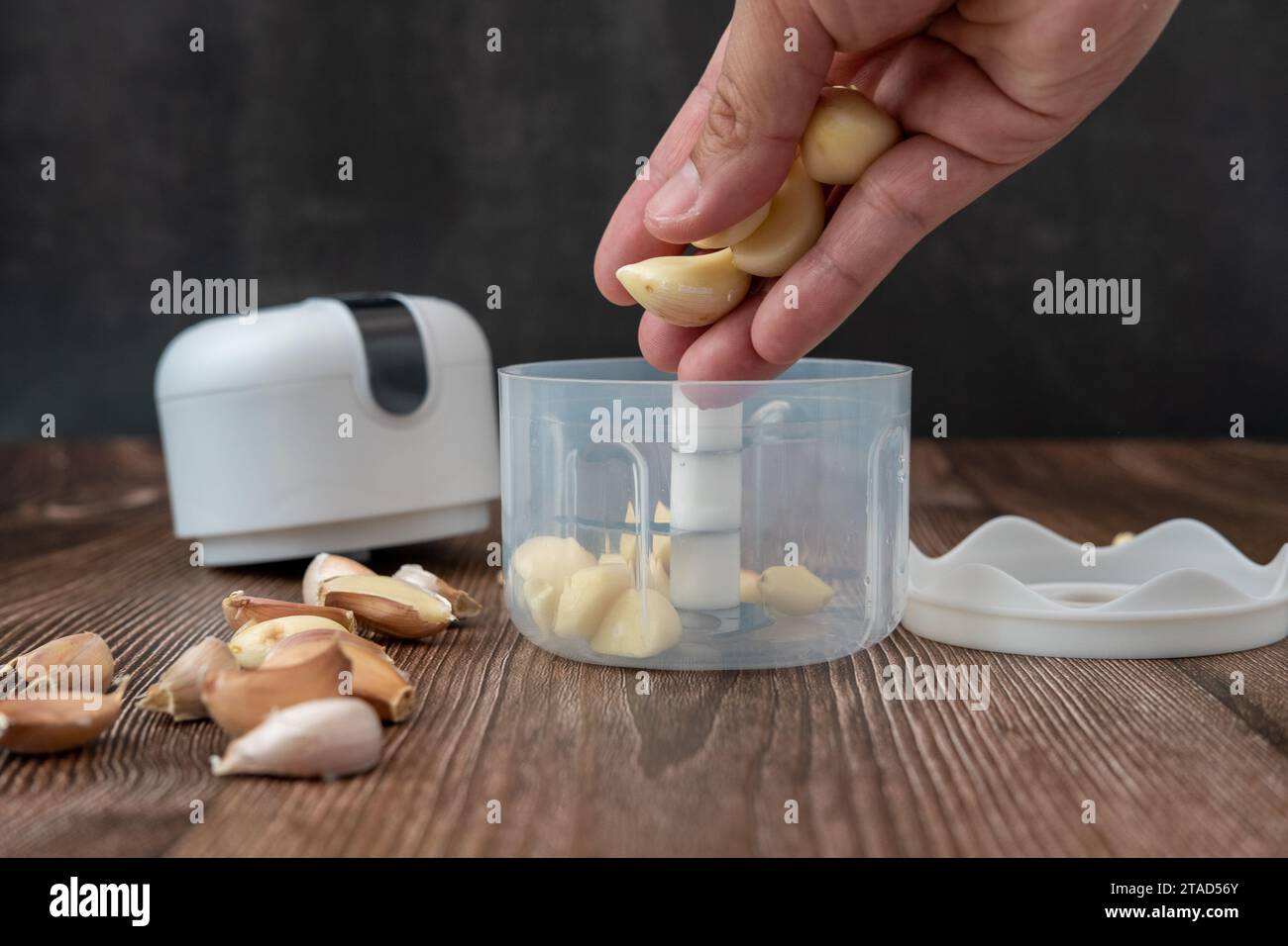 Male hands putting garlic in a blender Stock Photo - Alamy