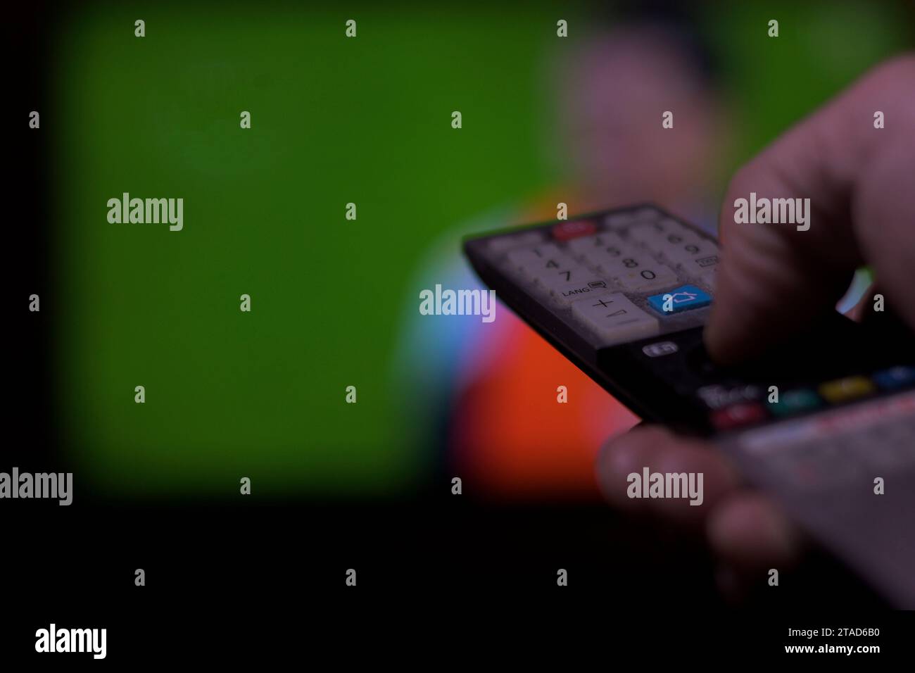 Hand with television remote control changing television channels ...