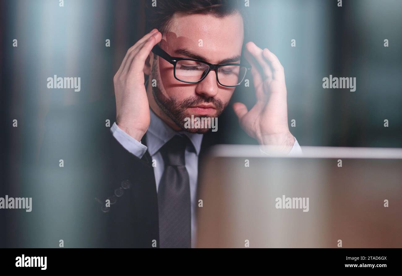 Tired man behind a computer screen from boring routine work in the ...