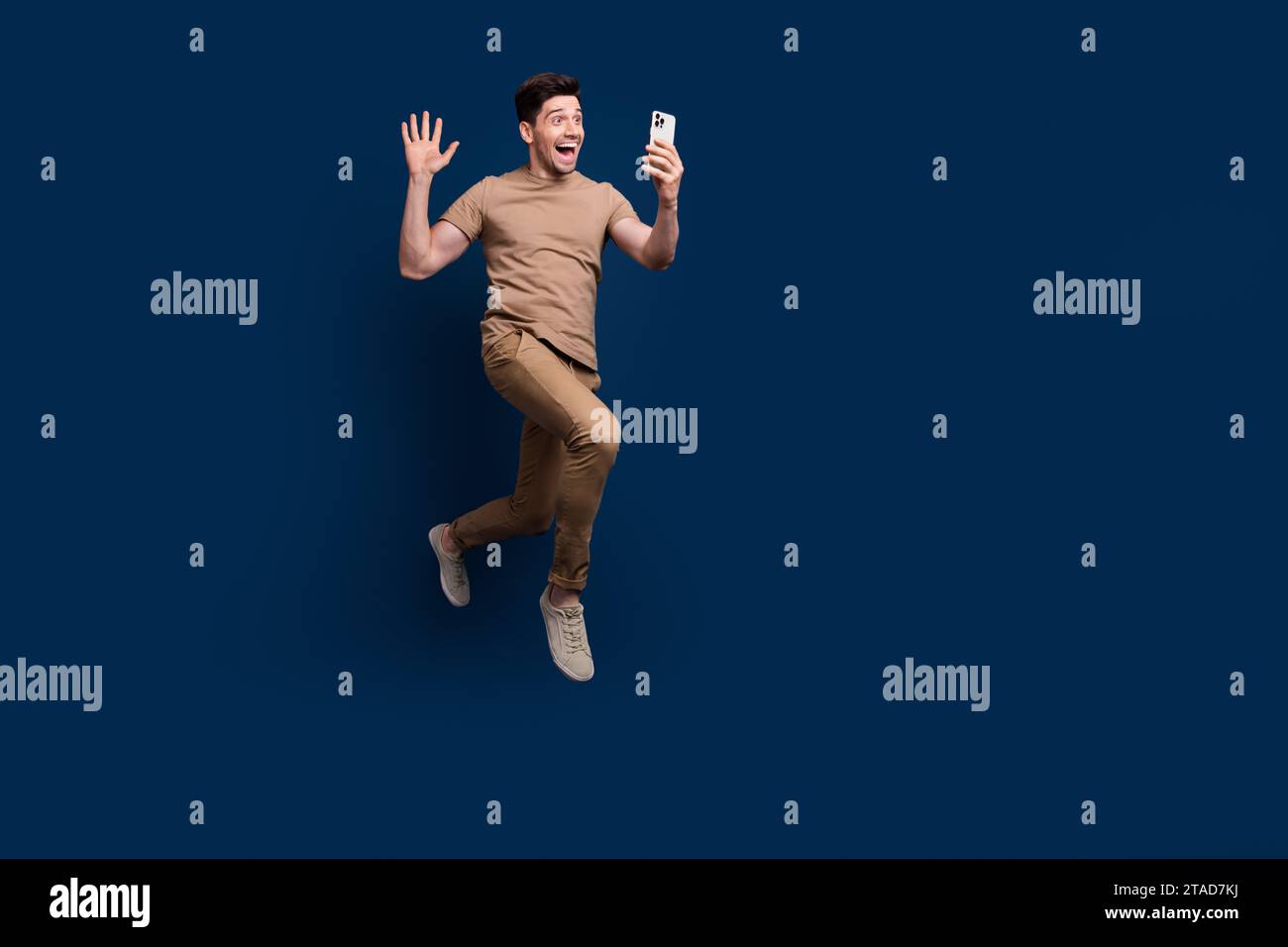 Full size photo of eccentric man wear beige outfit jumping talk on ...