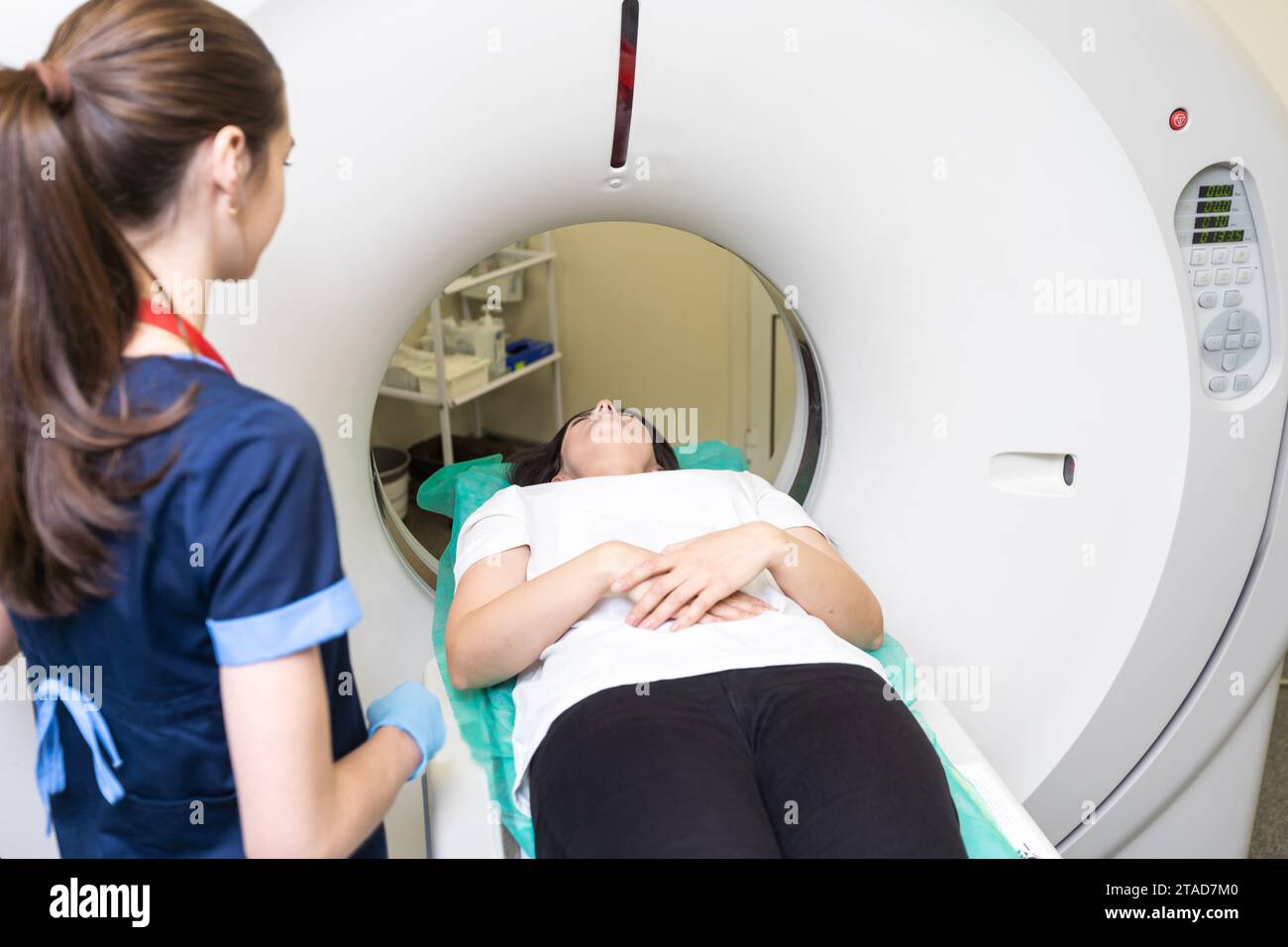 Pretty, young woman goiing through a Computerized Axial Tomography CAT ...