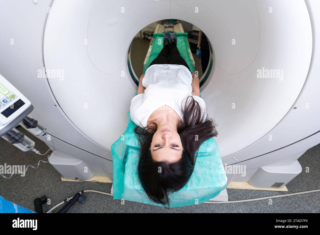 Radiologist with a female patient in the room of computed tomography ...