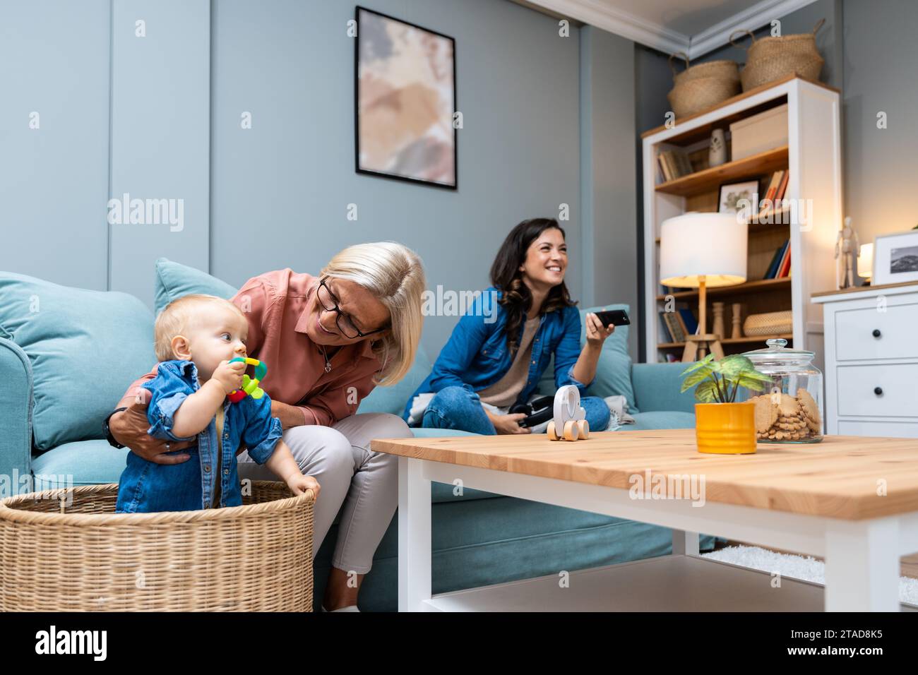 Young irresponsible mother watch TV and eat popcorn while her mother ...