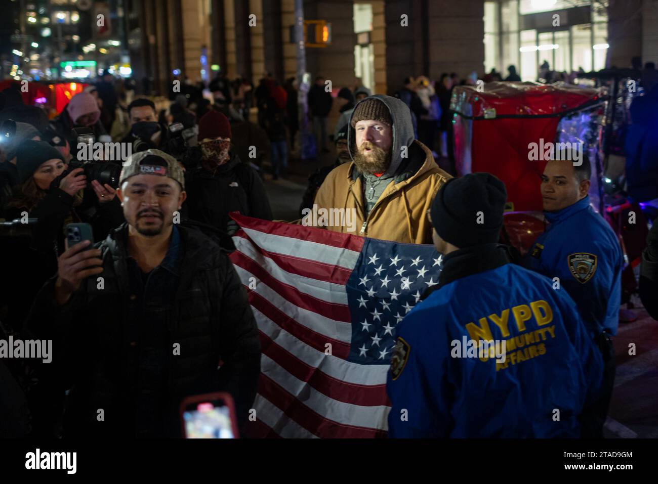NEW YORK, NEW YORK - NOVEMBER 29: A counter-protester is escorted by ...