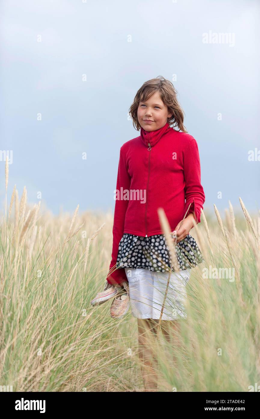 Girl walks contentedly through the high dune grass, Young, Holiday ...