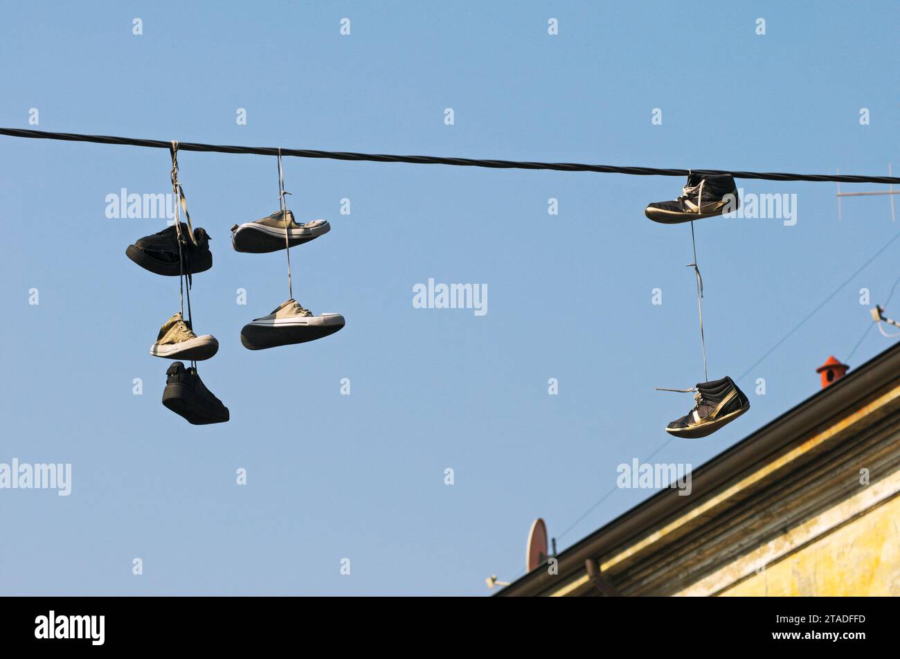 old shoes hanging on a power line Stock Photo - Alamy