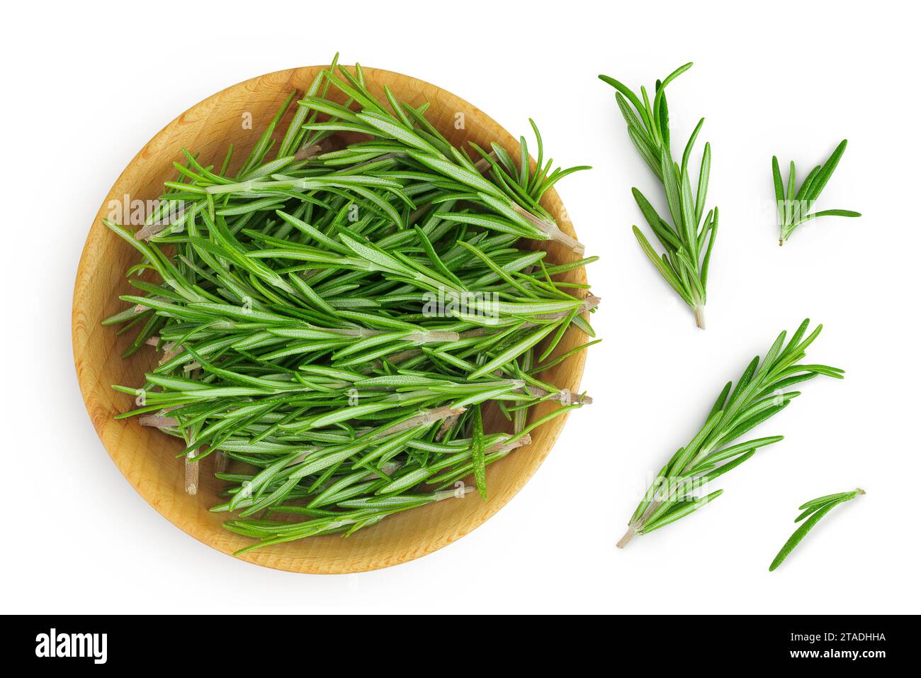 Rosemary twig and leaves in wooden bowl isolated on white background ...