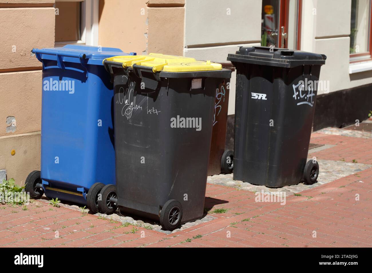 Colourful various recycling bins and waste bins, standing on the street ...