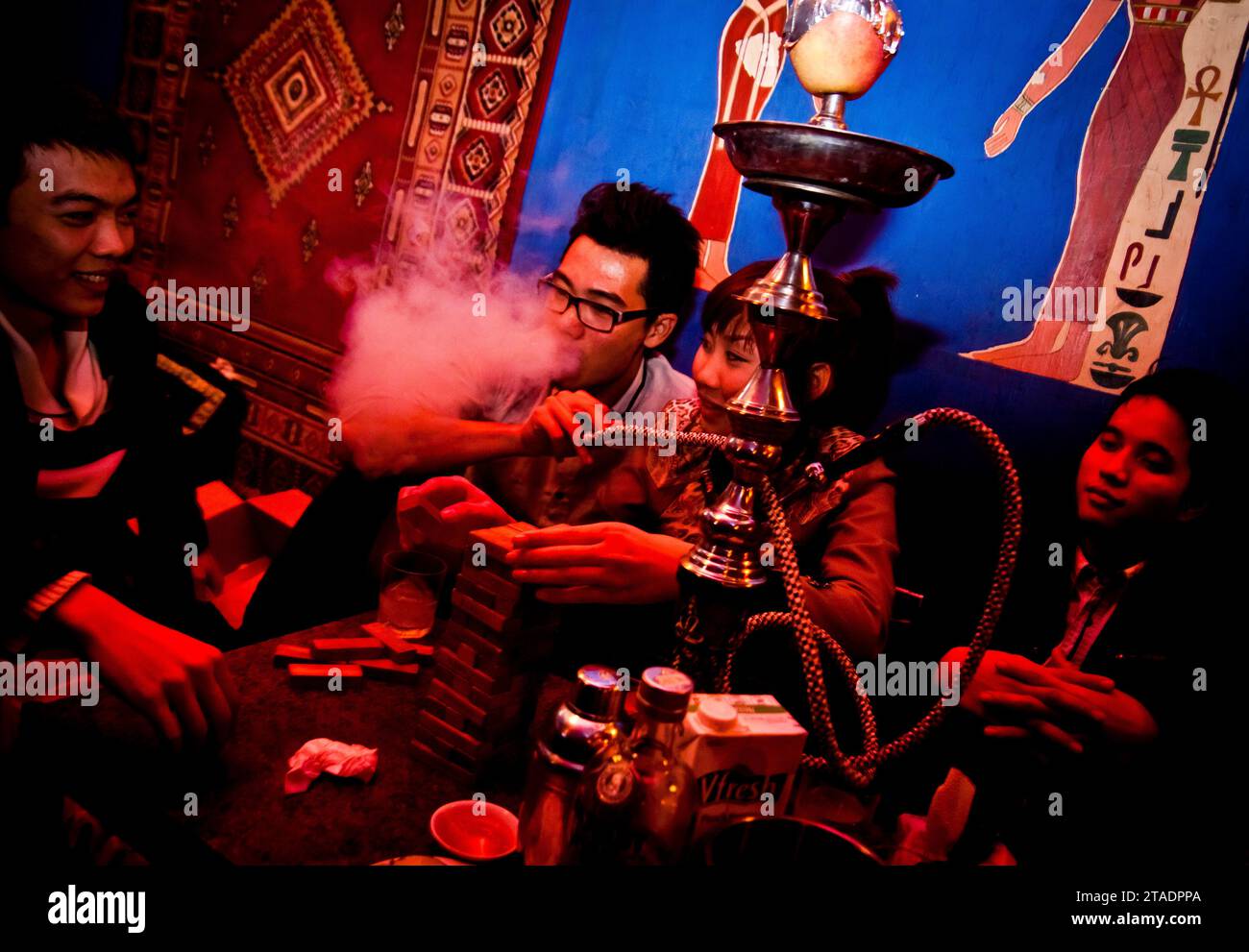 A young Vietnamese man smokes a shisha at Dragonfly Bar in Hanoi ...