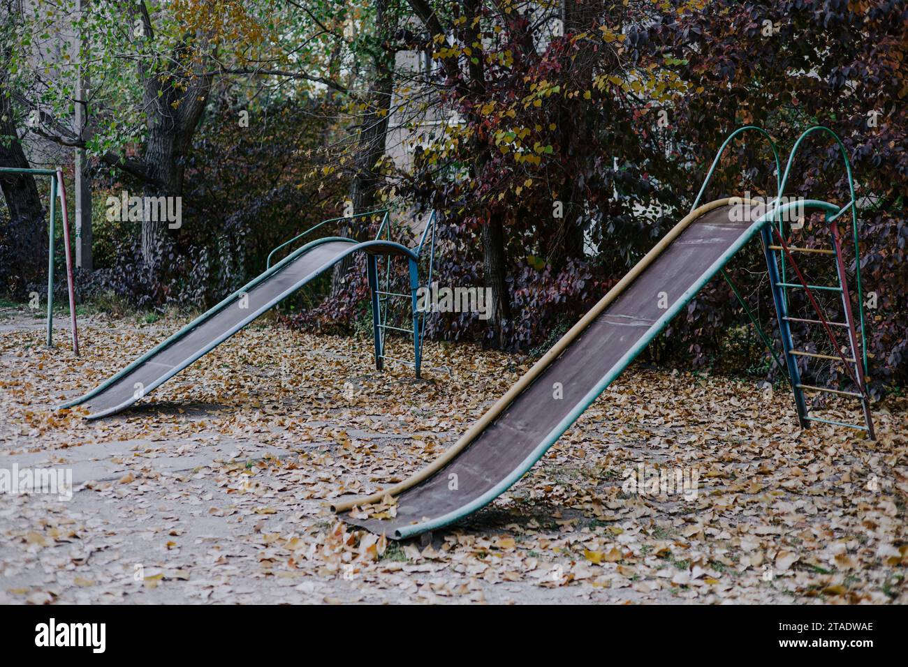 Two old unsafe metal multi-colored children's slides in the Soviet ...