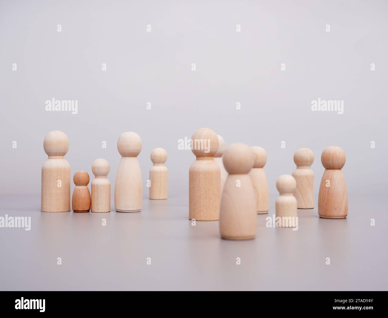 Wooden figures. A group of people standing together at a table ...