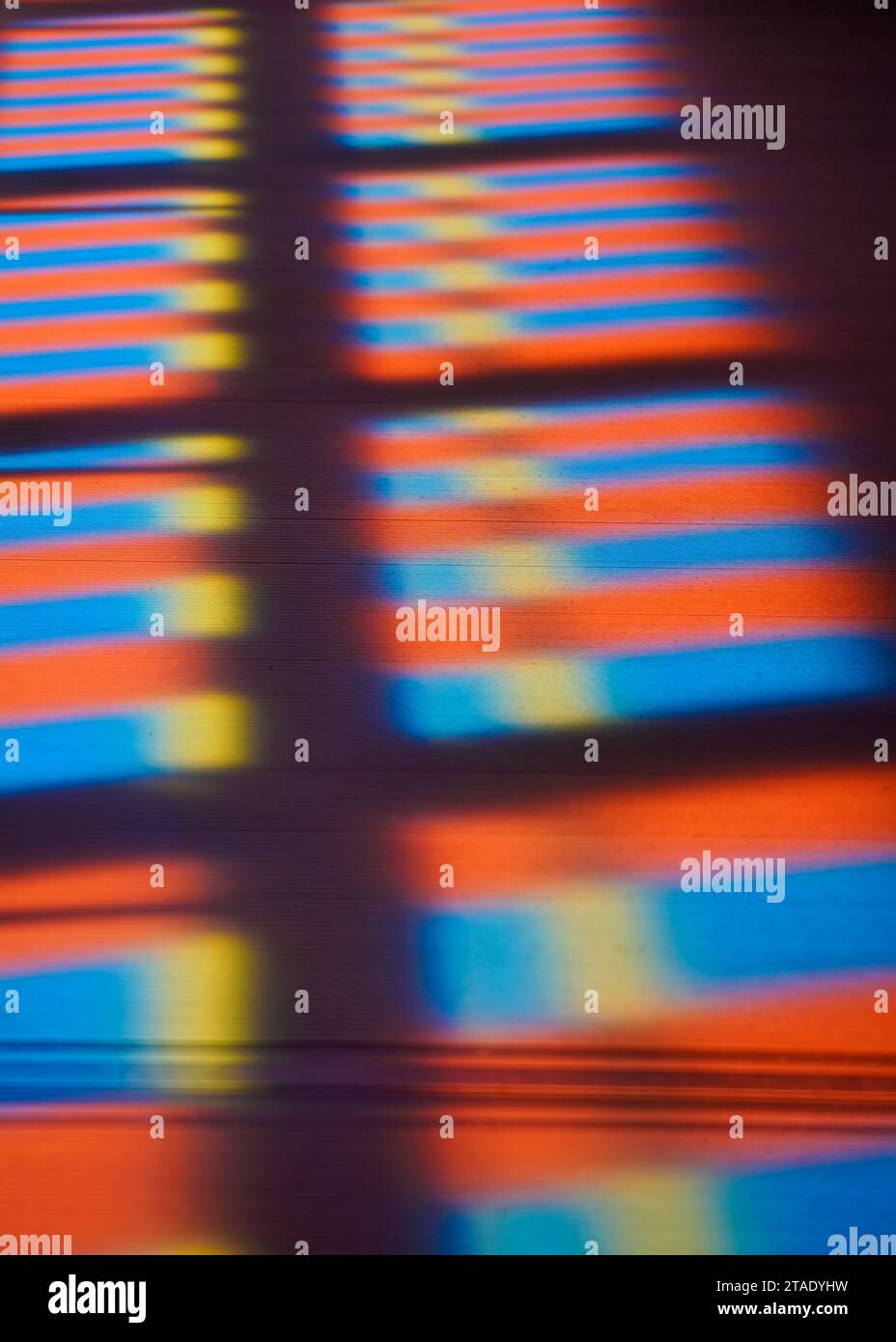 Abstract color shapes projected to ground, as sun shines through ...