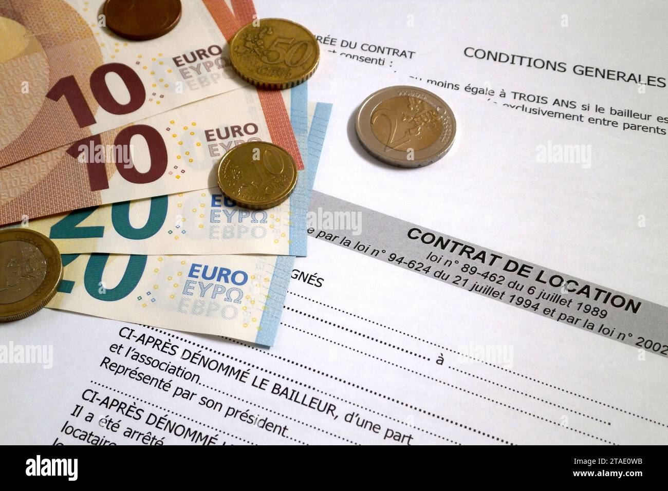 Some euro coins and banknotes on the top of a French house rental form ...