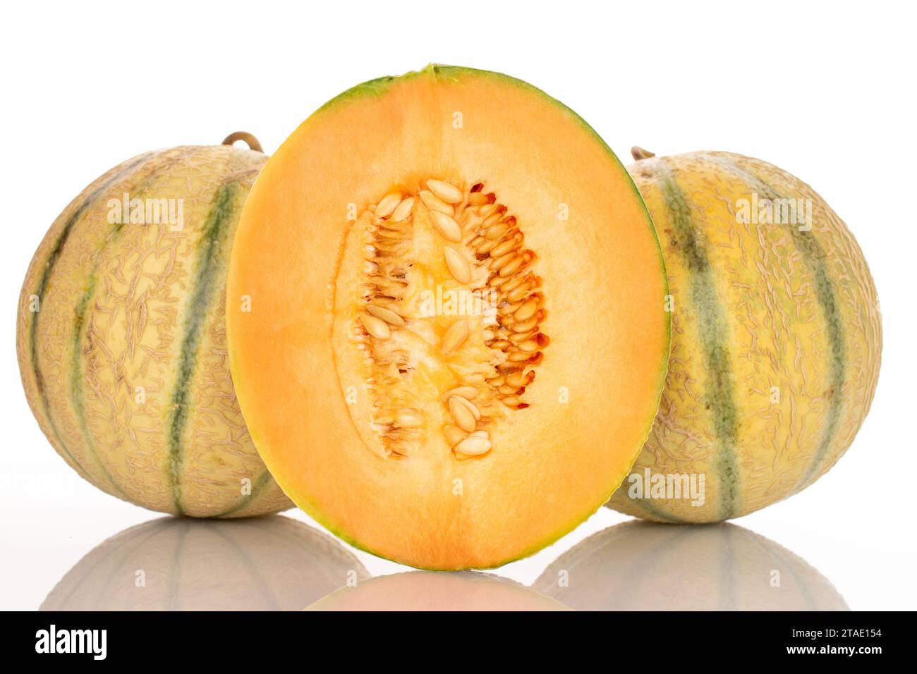 Two melons and one slice in focus, close-up, on a white background ...