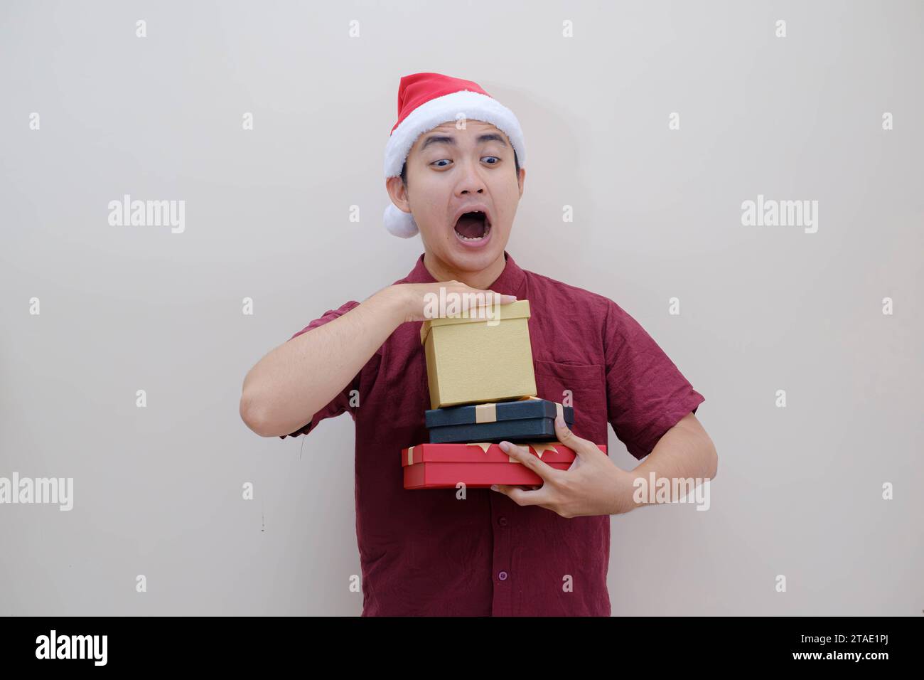 Young Asian Santa man drops Christmas boxes with shocked face ...