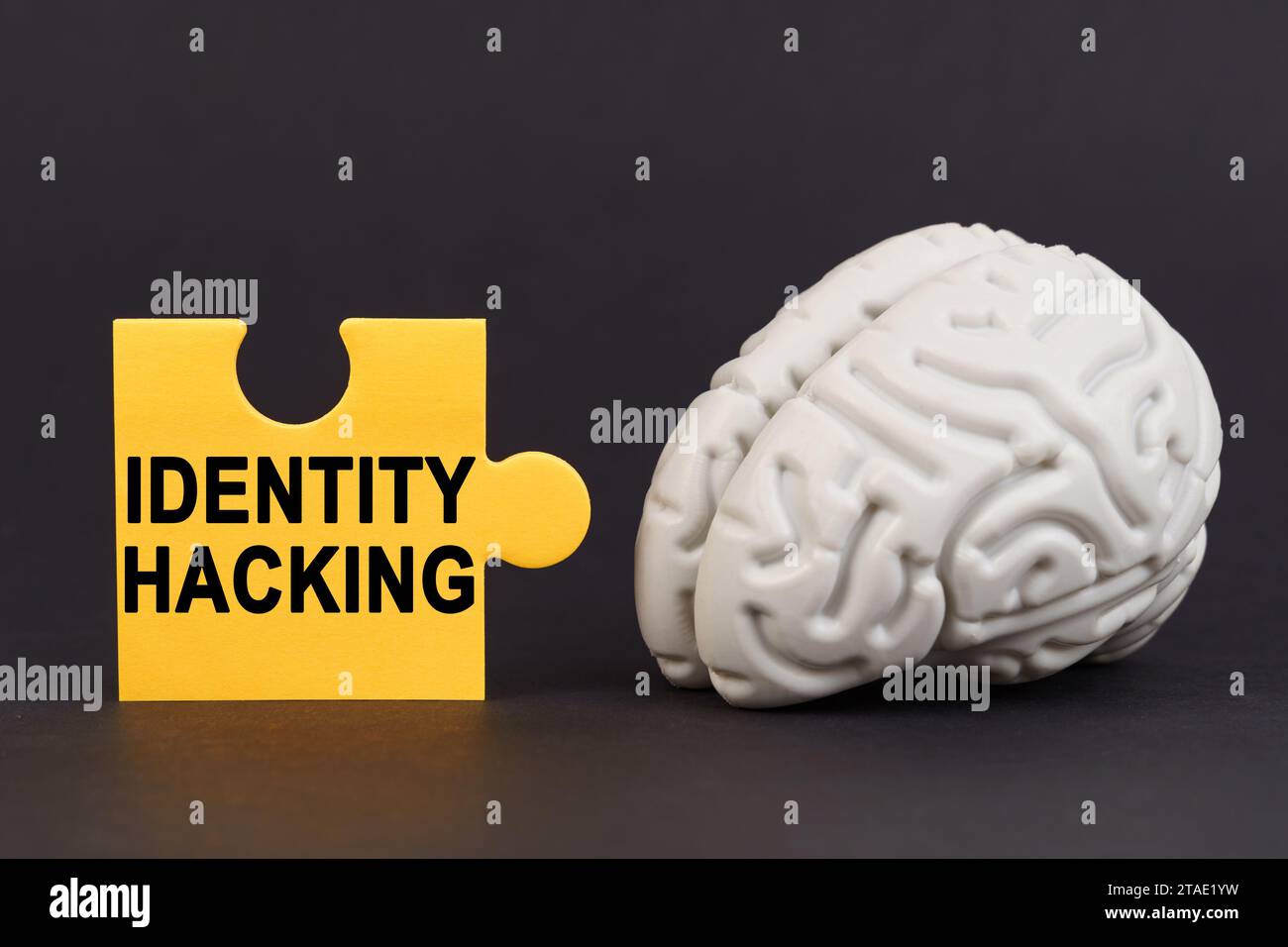 On a black surface there is a brain and a yellow puzzle with the ...