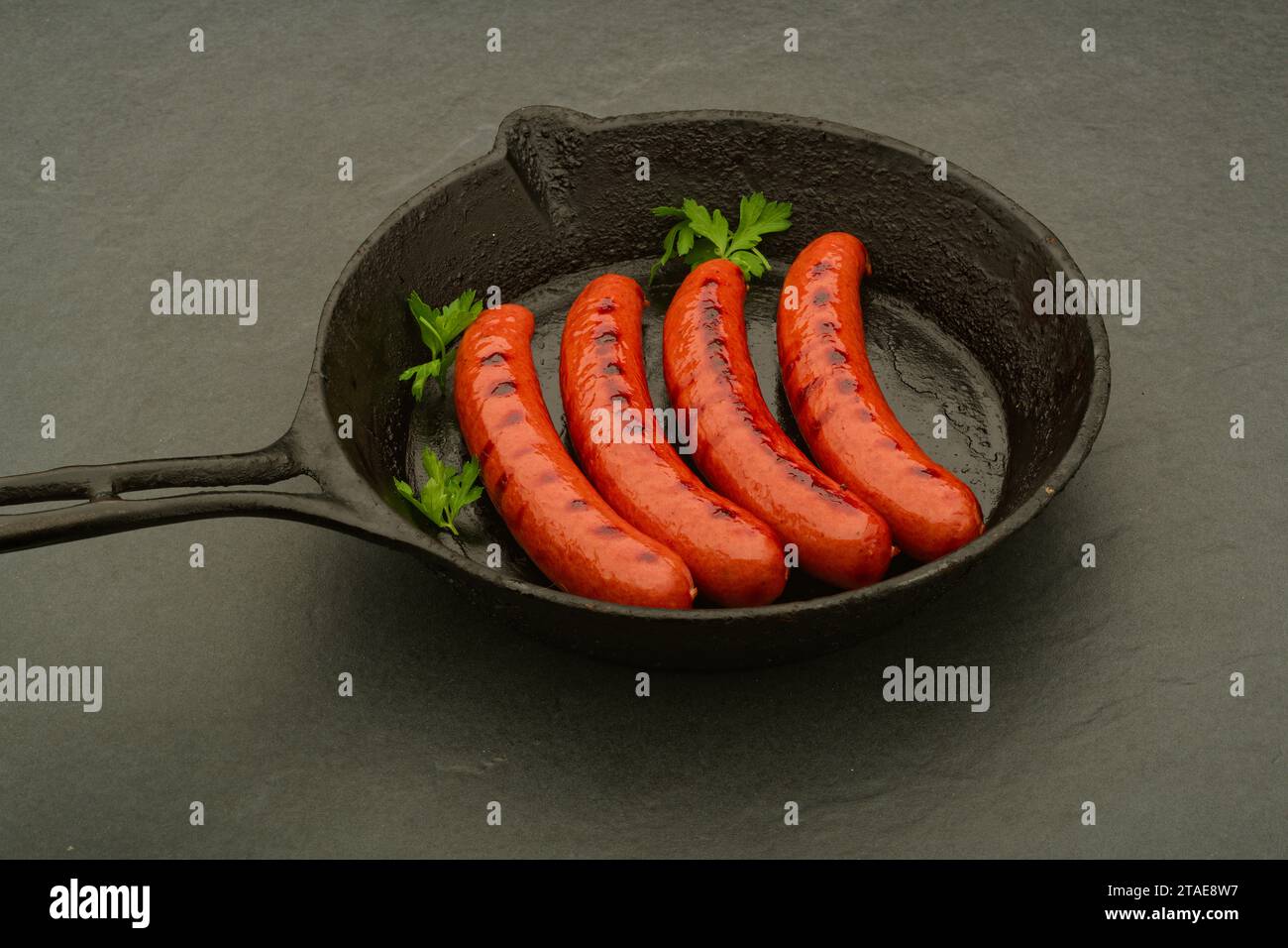German sausages being cooked. With parsley garnish Stock Photo - Alamy