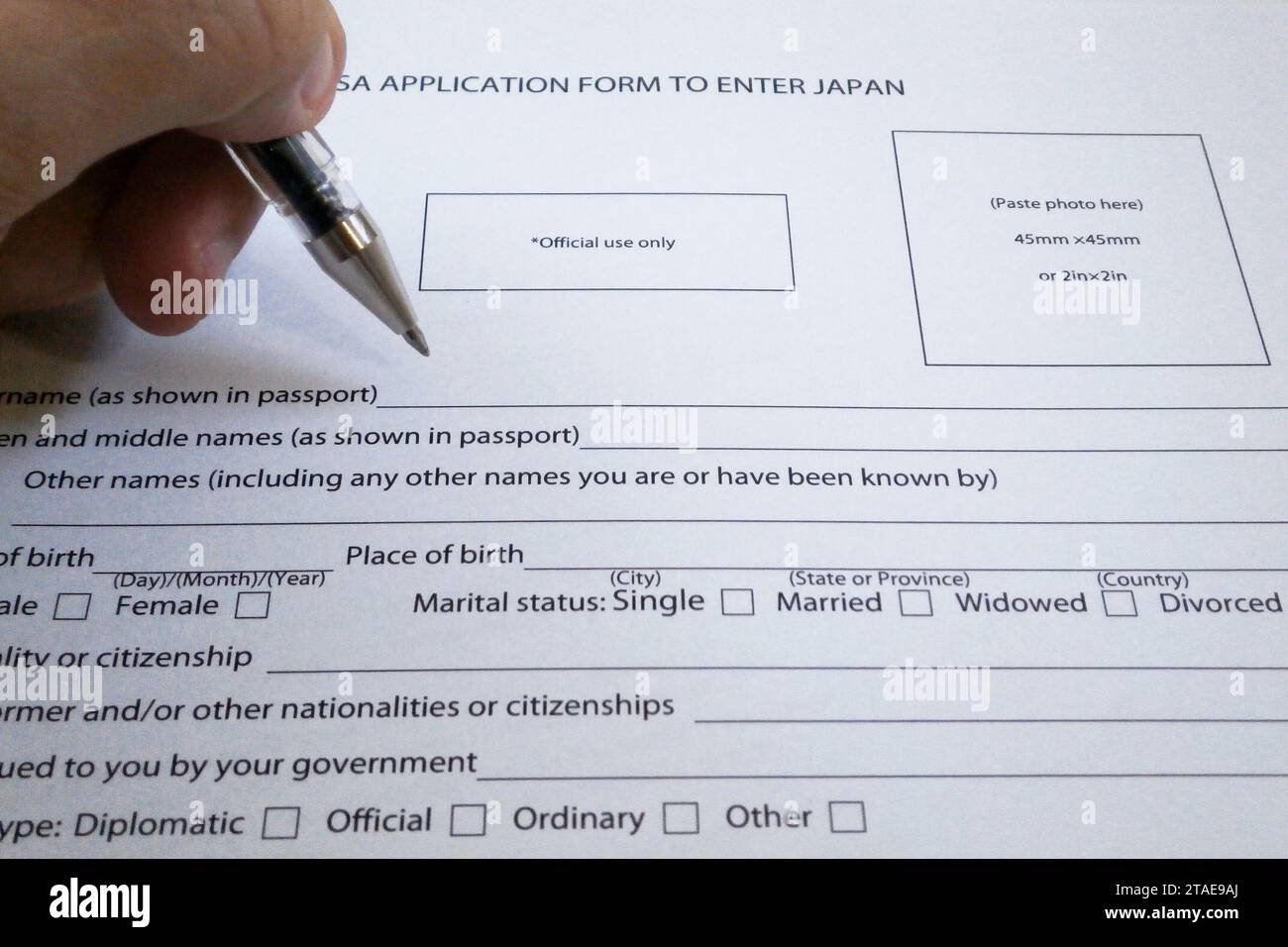 Ballpoint pen hold in the hand of a man filling a visa application for ...