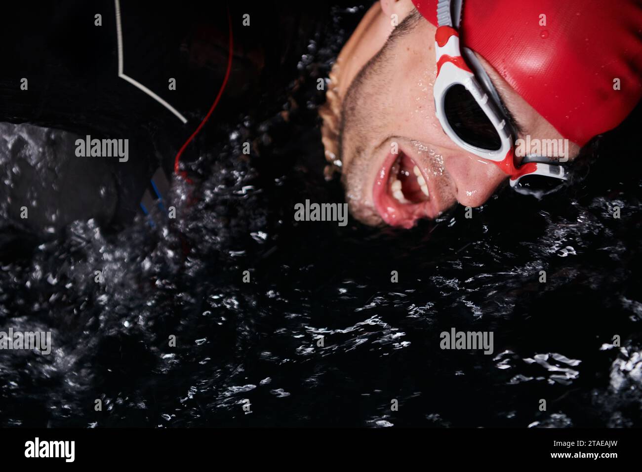 authentic triathlete swimmer having a break during hard training on ...