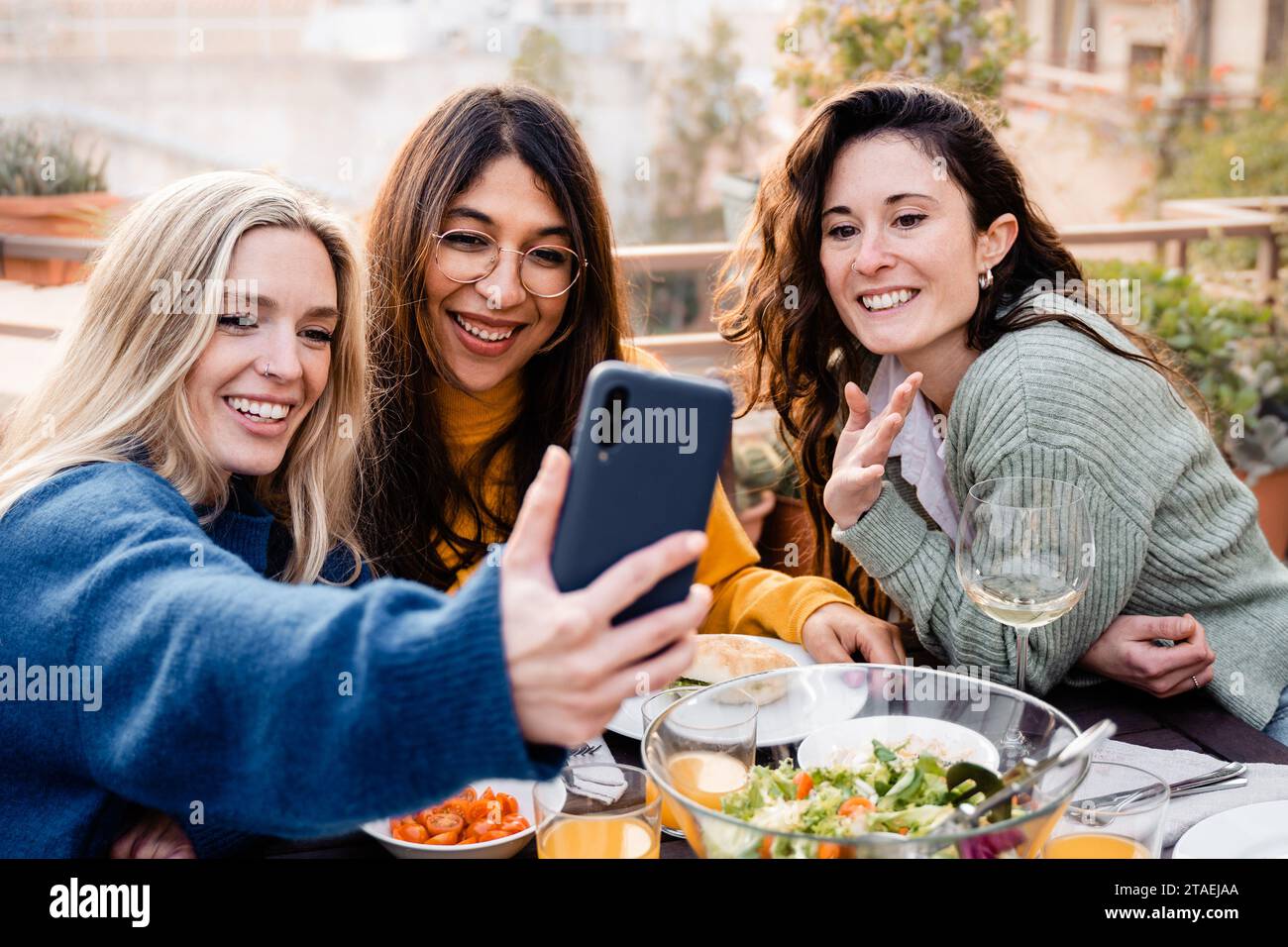 Happy friends having fun at vegan dinner party. Group of people taking ...