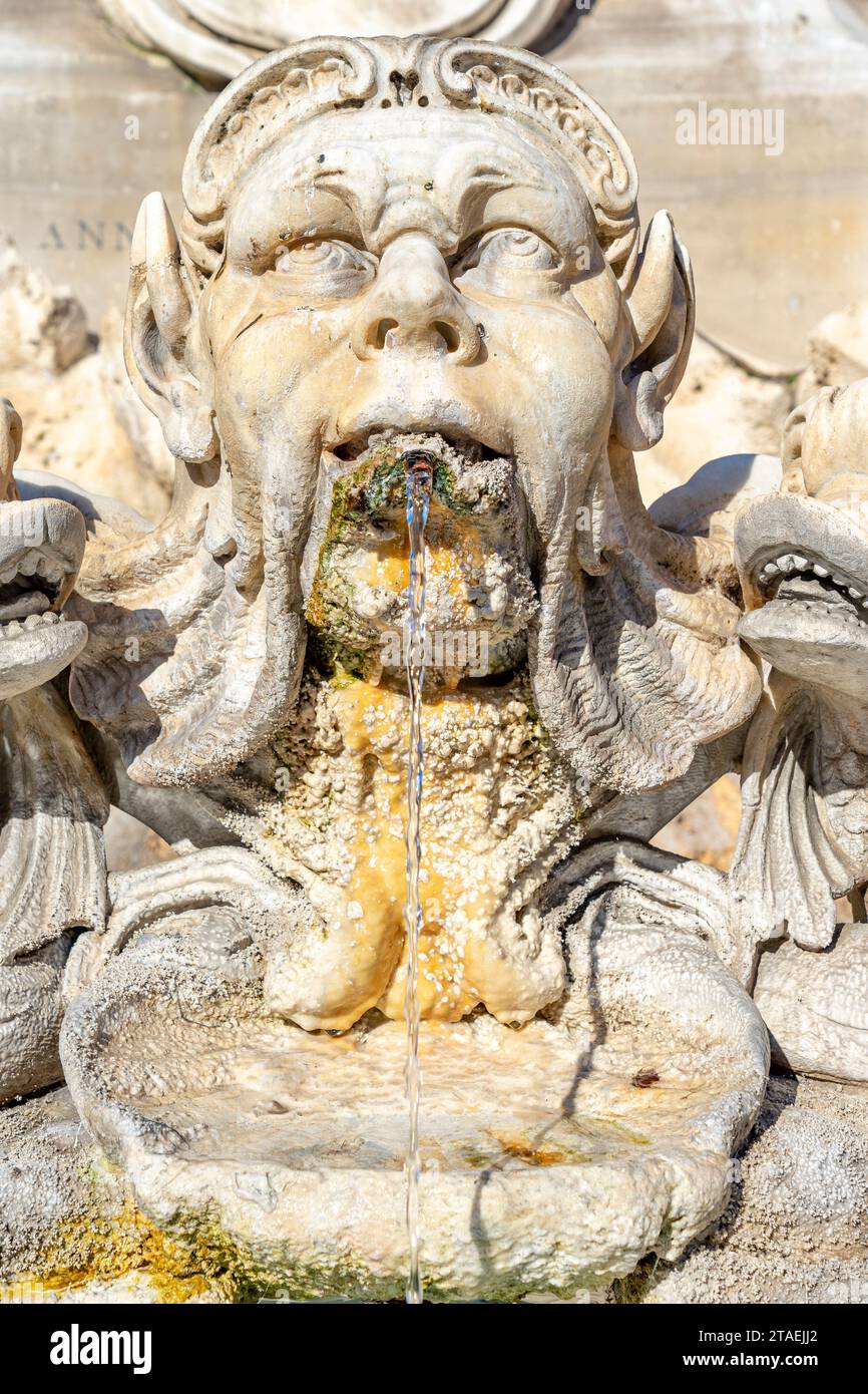stone statue gushing water from the mouth with human representation ...