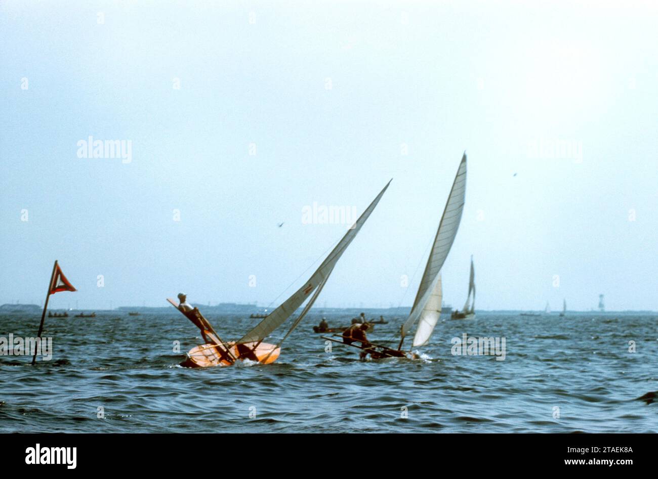 SHEEPSHEAD BAY, NY - AUGUST, 1954: Two deck sails are seen by a buoy ...