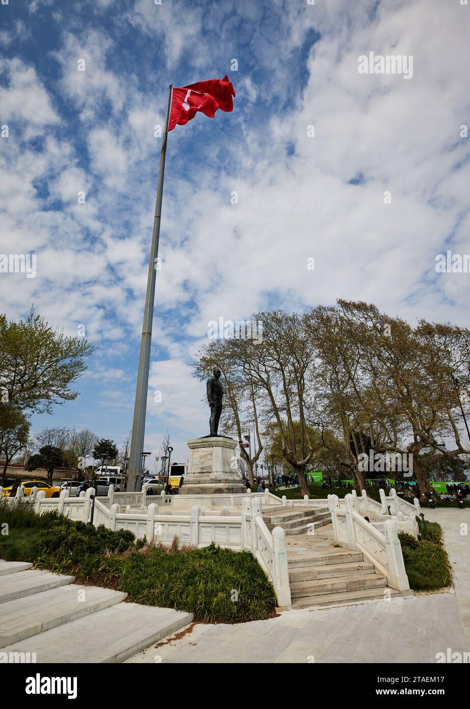 A Turkish flag displayed next to a monument in a scenic park beside a ...