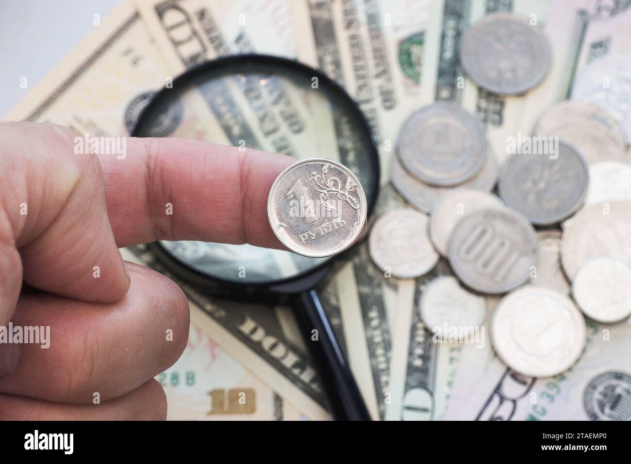 Ruble coin with a magnifying glass against the backdrop of the economic ...