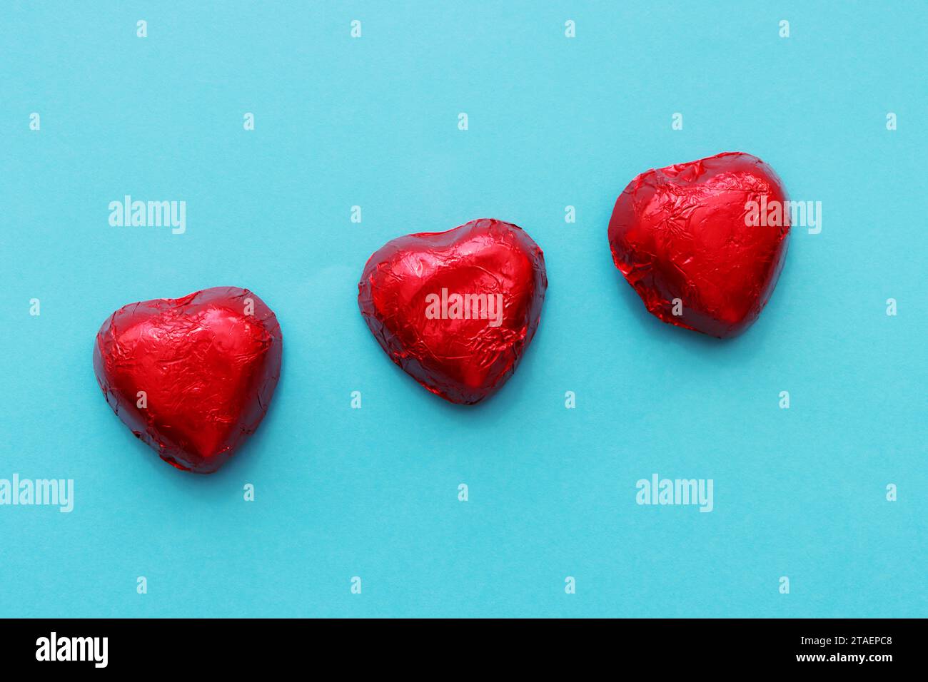 Three candies on a blue background Stock Photo - Alamy