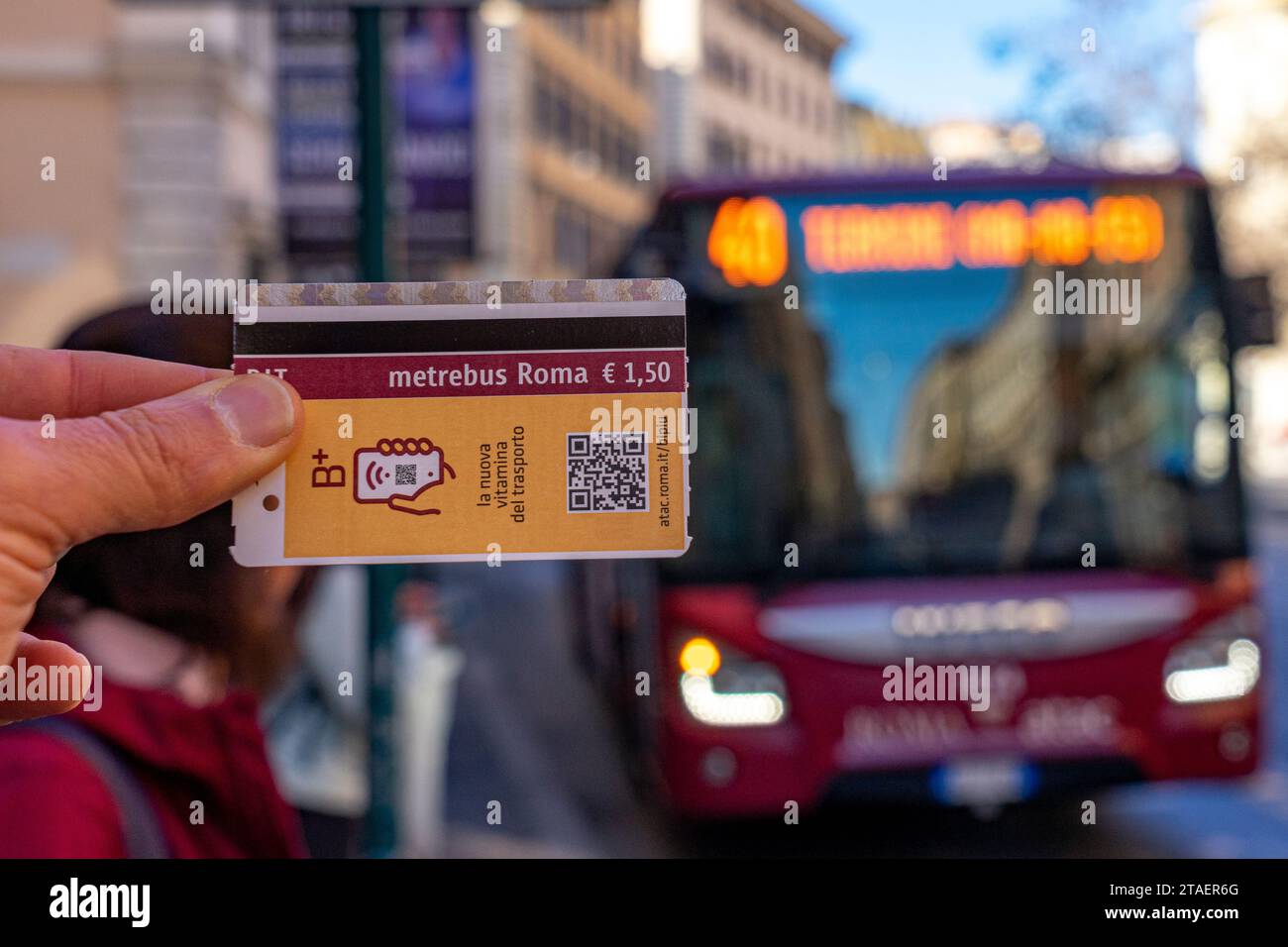 Ticket or transport ticket for city buses held in hand with blurred bus ...
