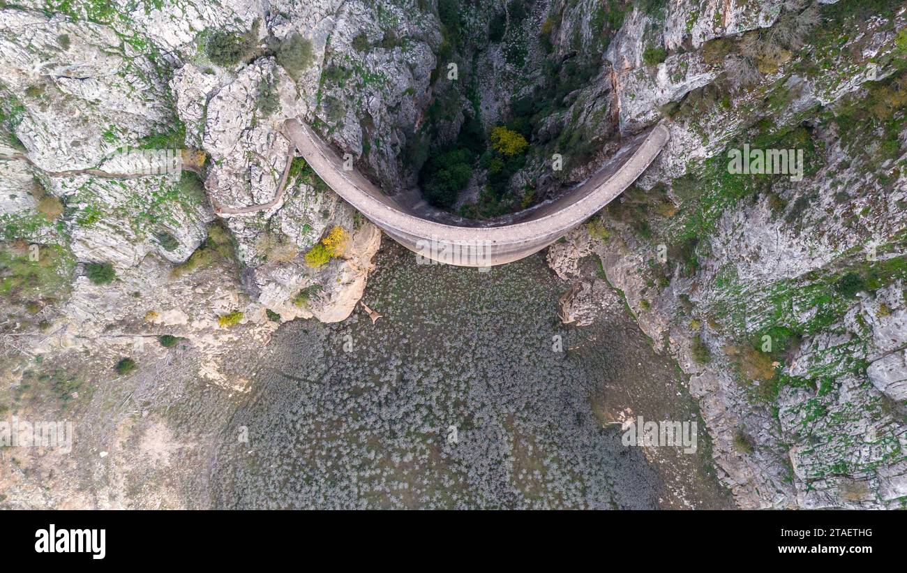 Aerial view of a natural stone arch bridge over a rocky canyon with ...