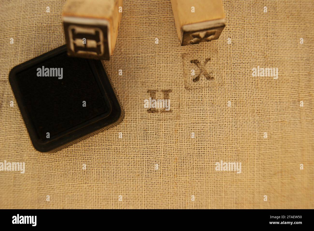 Stamp letters X and H on linen cloth. Letters on cloth Stock Photo - Alamy