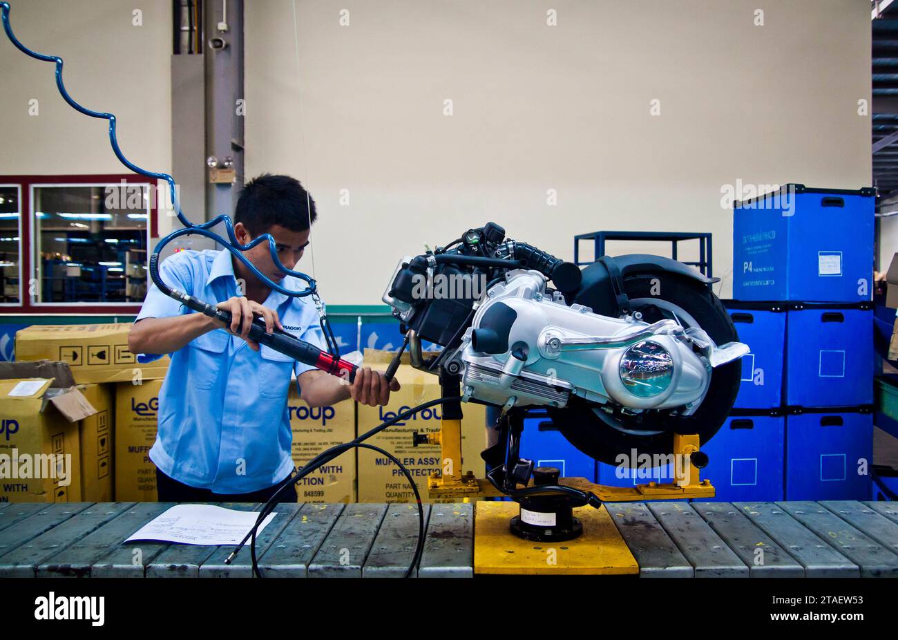 Workers assemble Vespas on the assembly line at the Piaggio Factory ...