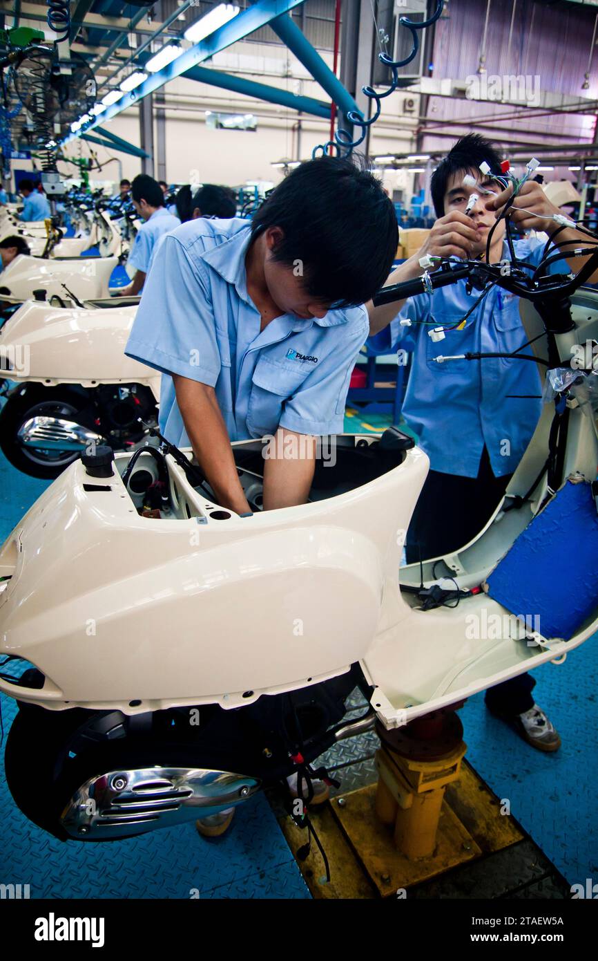 Workers assemble Vespas on the assembly line at the Piaggio Factory ...