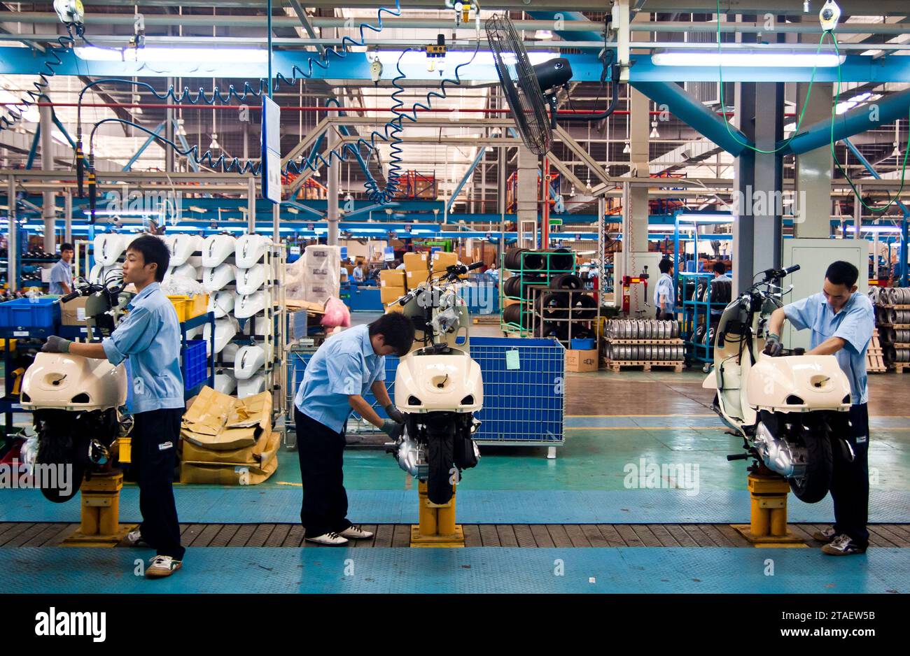 Workers assemble Vespas on the assembly line at the Piaggio Factory ...