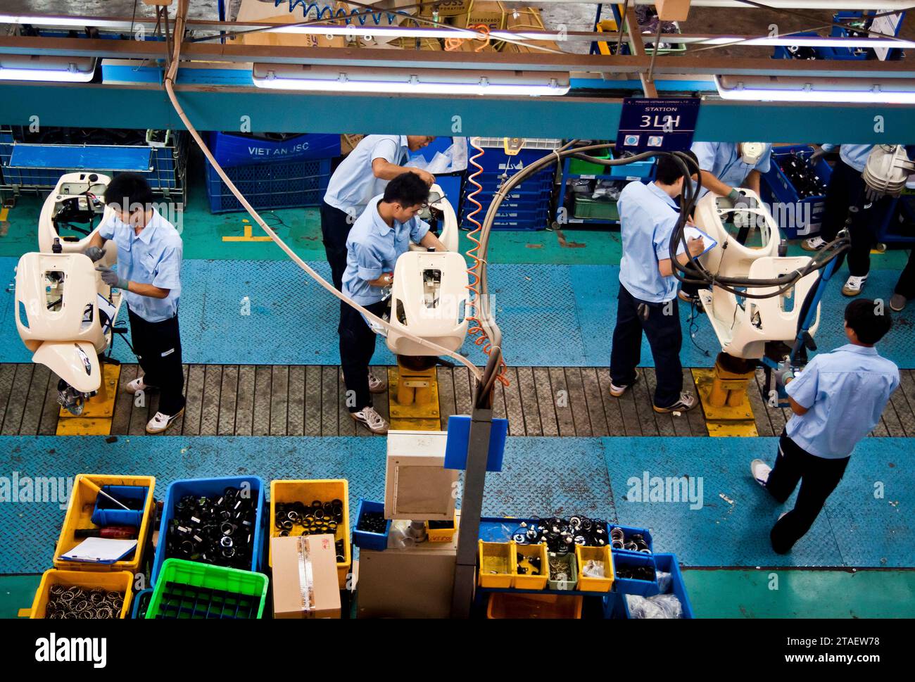 Workers assemble Vespas on the assembly line at the Piaggio Factory ...