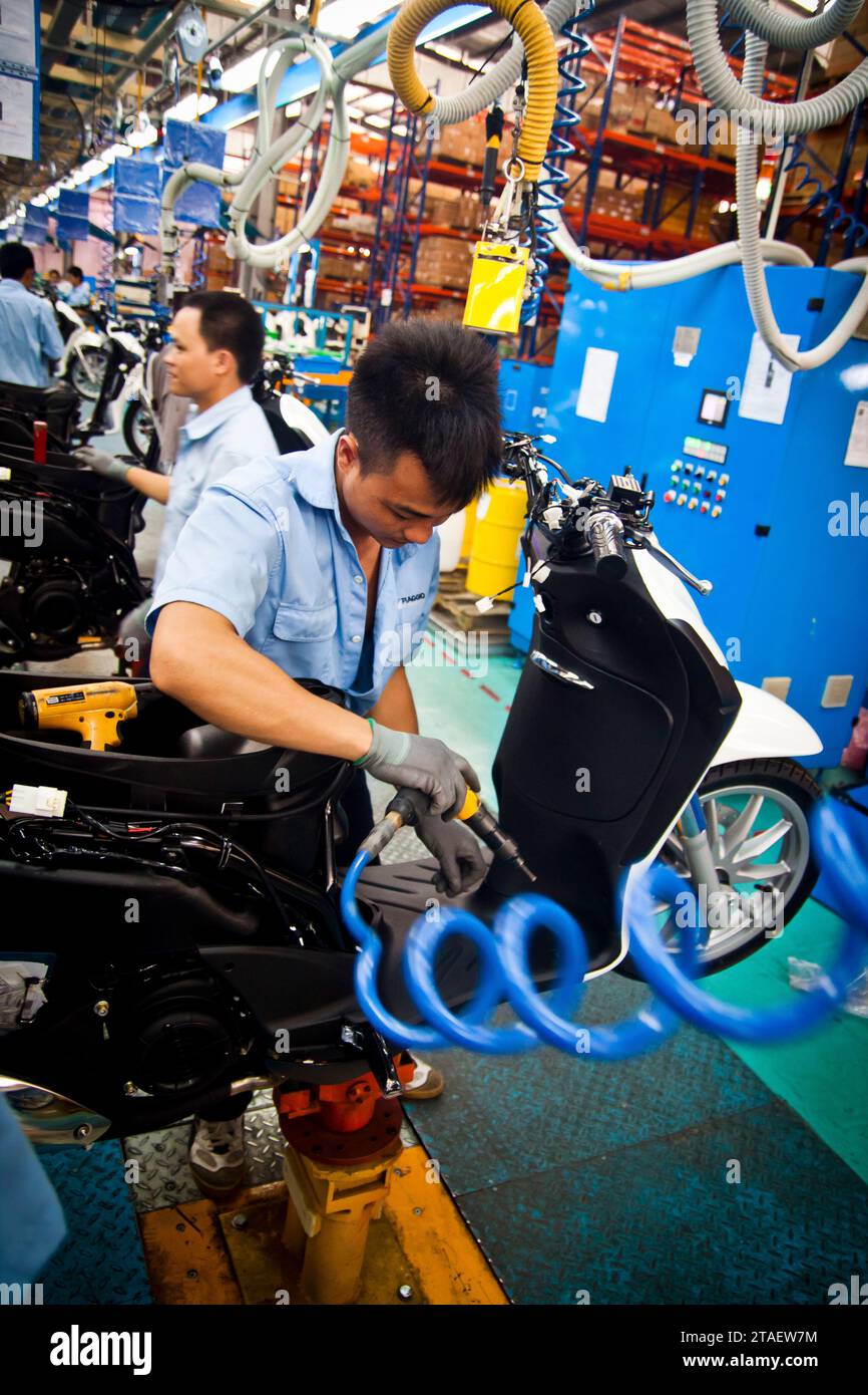 Workers assemble Vespas on the assembly line at the Piaggio Factory ...