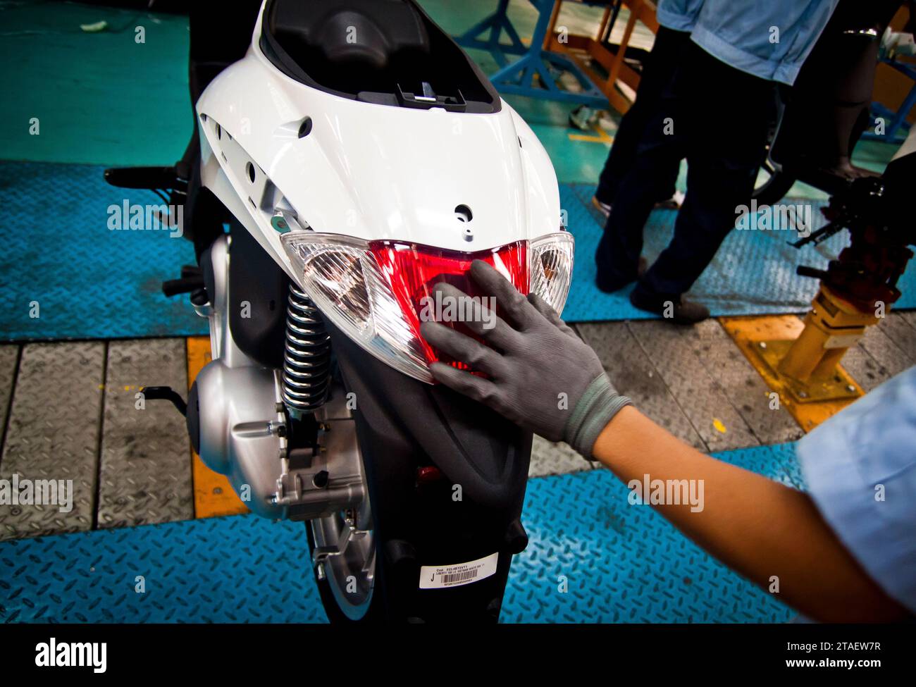 Workers assemble Vespas on the assembly line at the Piaggio Factory ...