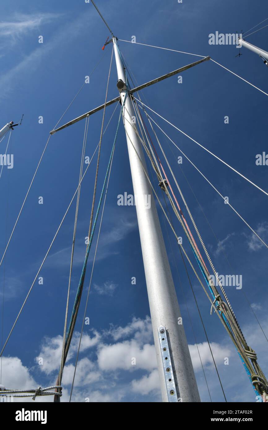 sailing boat mast and riggingwithout sails attached aginst blue sky ...