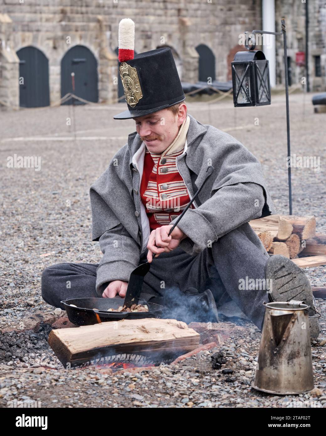 reenactment of Canadian soldier from Victorian era cooking meal on open ...