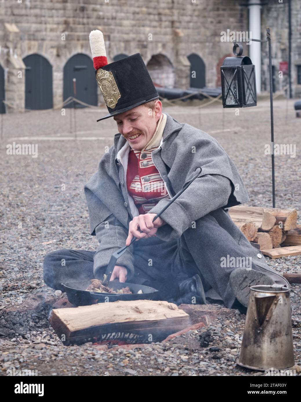 reenactment of Canadian soldier from Victorian era cooking meal on open ...