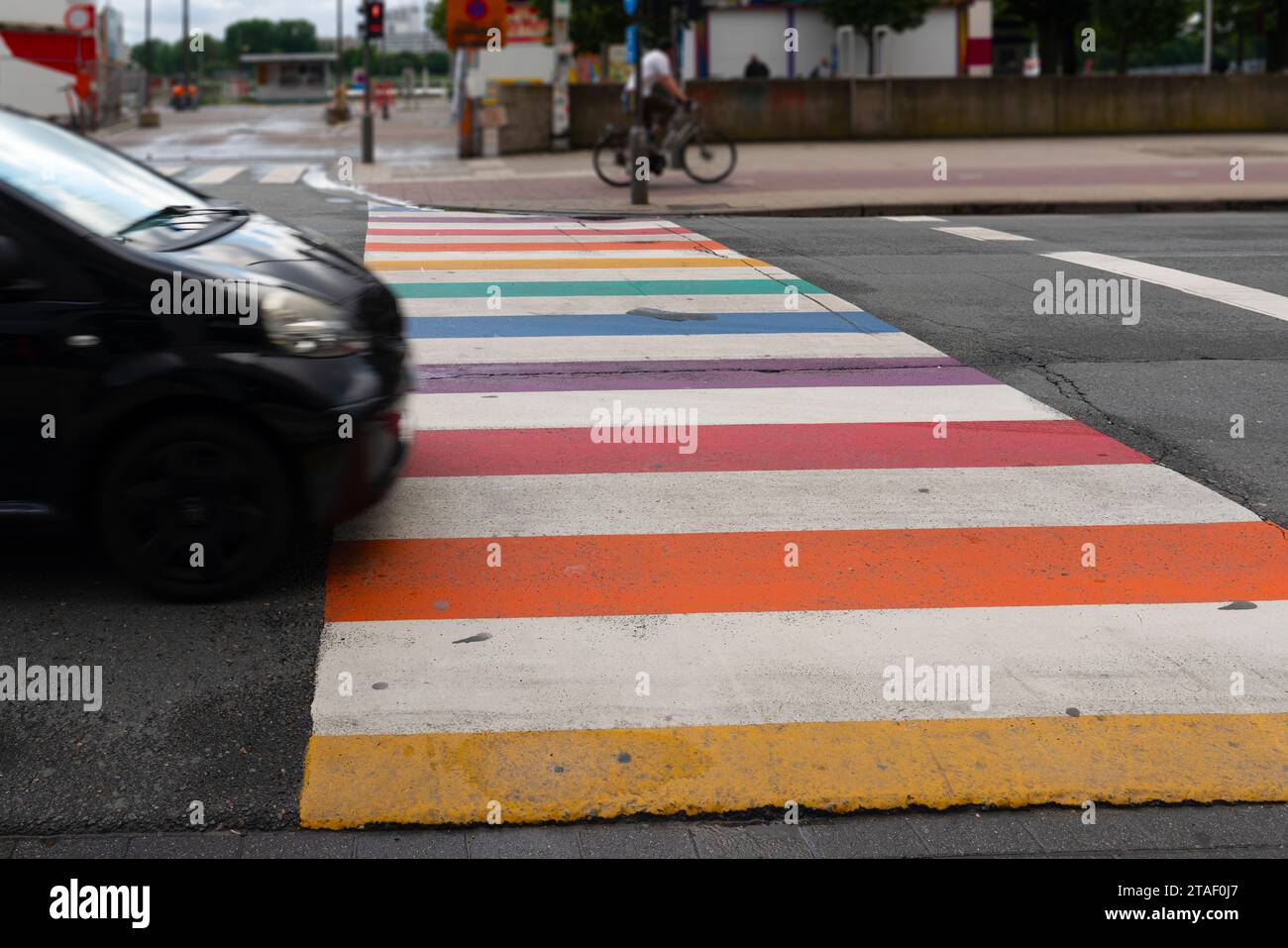 Pedestrian crossing painted in rainbow colors and blurred car. Belgian ...