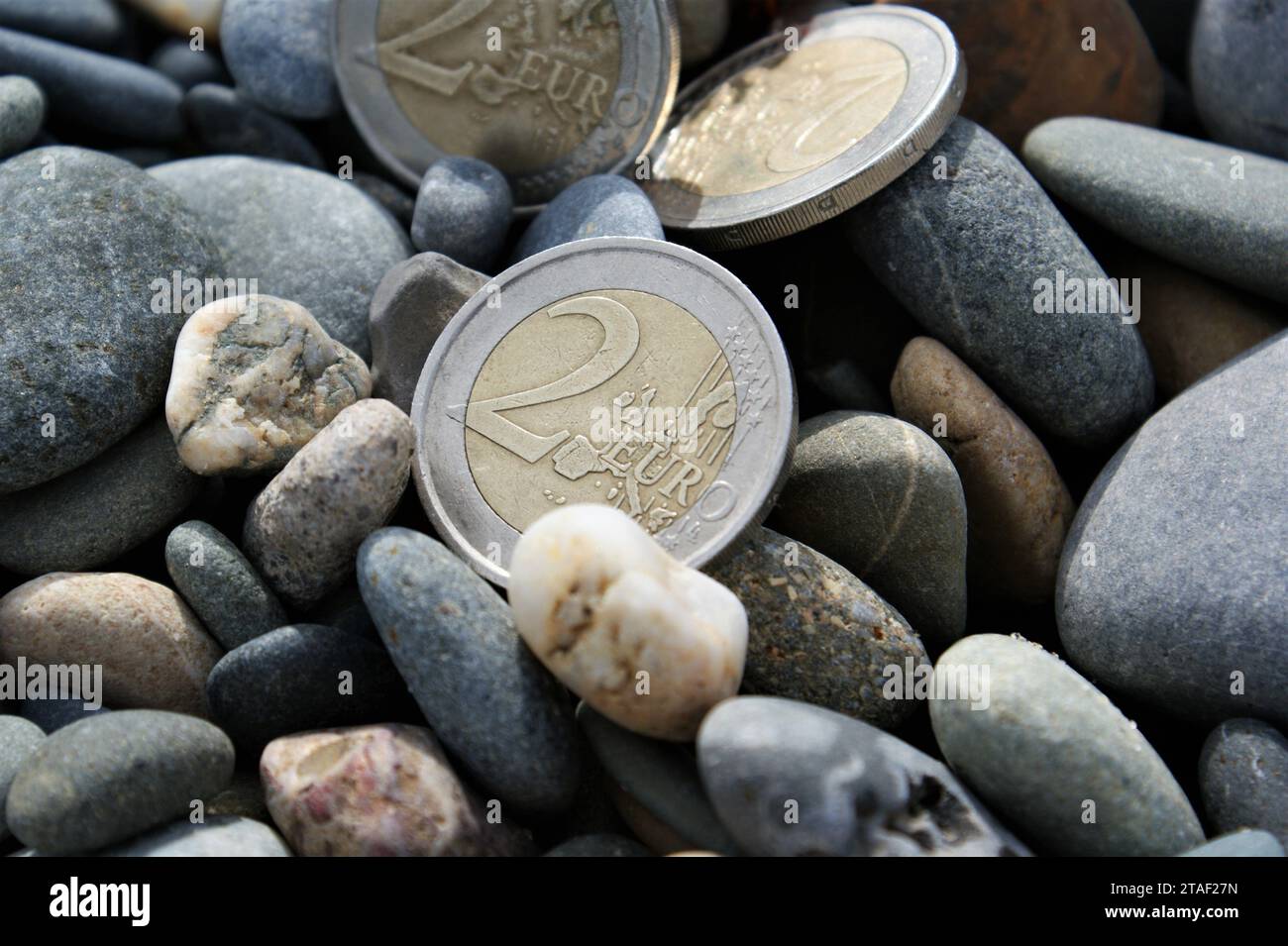 Three two euro coins. 2 euro coins in pebbles Stock Photo - Alamy